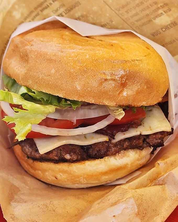 Layers of lettuce, tomato, and perfectly melted cheese create a burger that photographs as beautifully as it tastes.