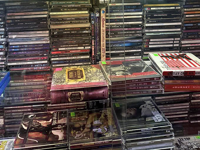 The CD collection spans decades of musical history, a physical playlist from an era before streaming when album art was an experience and liner notes were literature.