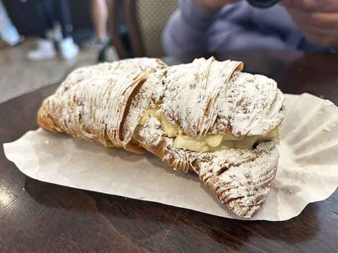 A lobster tail pastry dusted with powdered sugar, because sometimes breakfast needs to feel like a celebration.