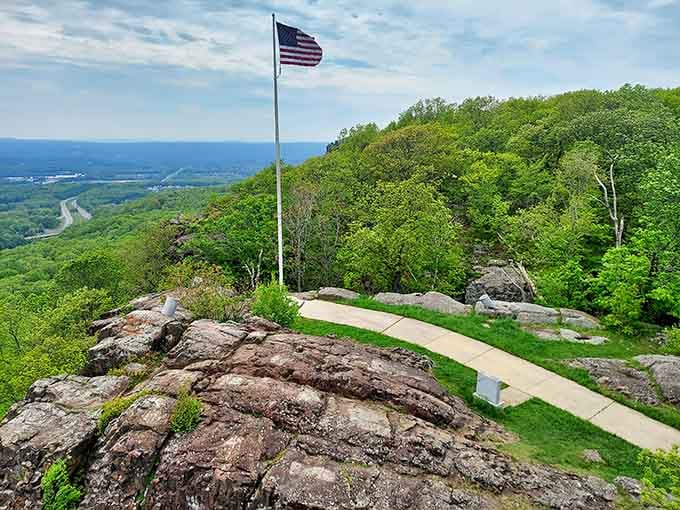 Old Glory waves proudly above the rocky summit, framing views that stretch across multiple states.