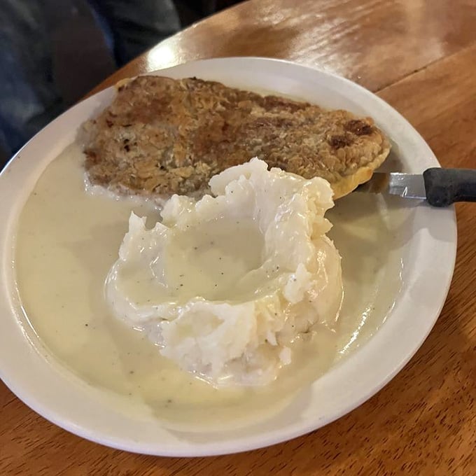 The chicken fried steak comes bathed in creamy gravy, a testament to the fact that some foods are meant to be smothered in love.