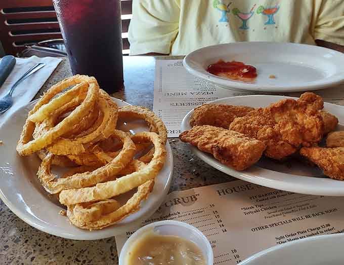 Golden onion rings stacked high next to crispy chicken tenders prove that sometimes the classics are classic for a reason.
