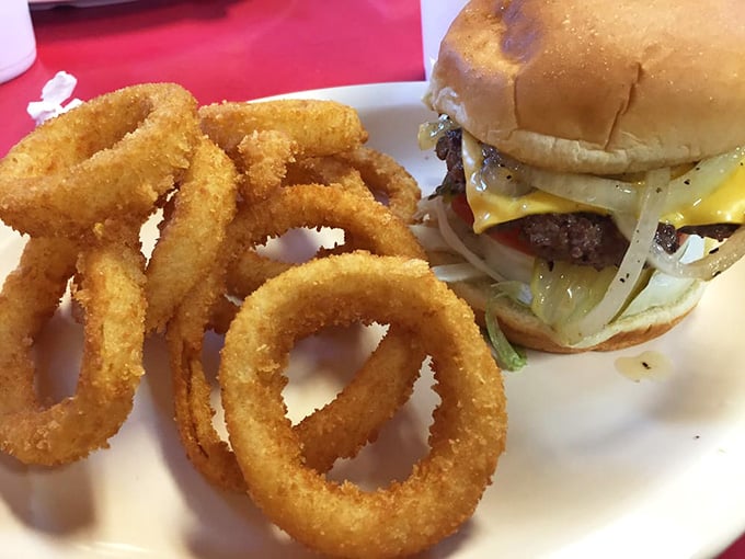 Golden onion rings circling a cheeseburger like Saturn's rings around pure, delicious happiness.