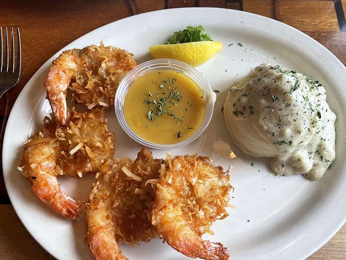 The coconut shrimp arrives like tropical ambassadors on a white plate &ndash; crispy, golden treasures accompanied by fluffy mashed potatoes and melted butter.
