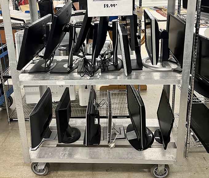 Computer monitors lined up like eager job applicants, each one ready to light up someone's home office for a fraction of retail price.