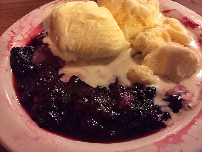 Blackberry cobbler with ice cream melting into warm fruit is basically summer in a bowl.