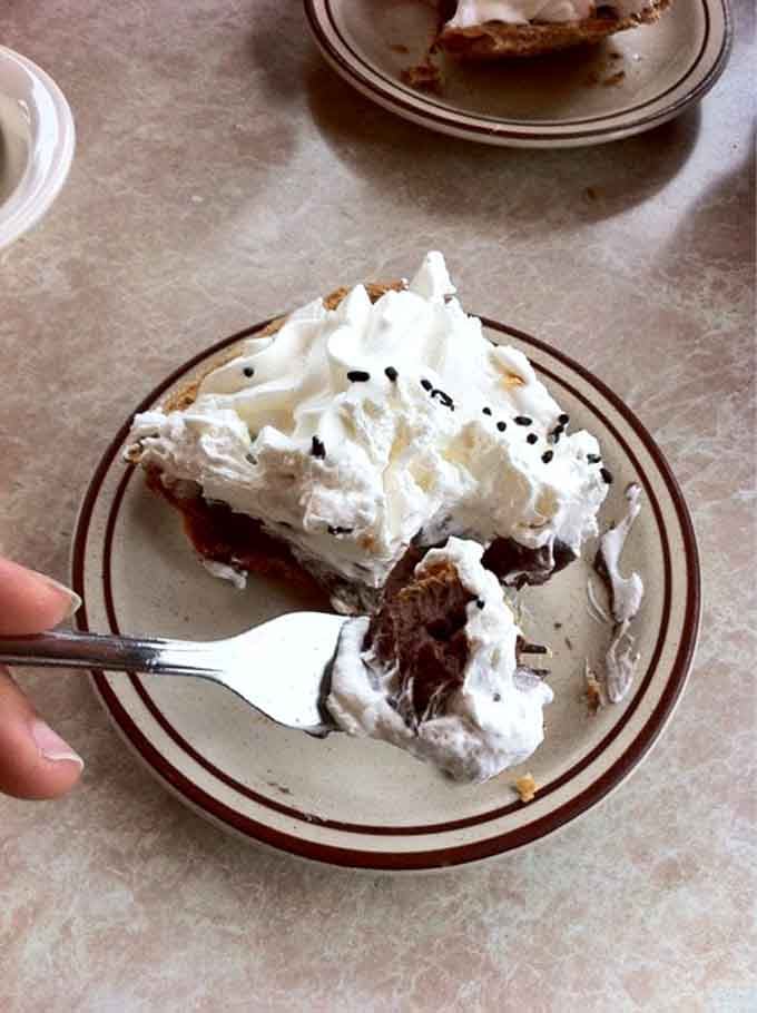 This isn't just pie—it's edible architecture. Towering meringue crowns a chocolate cream filling so rich it should have its own tax bracket.