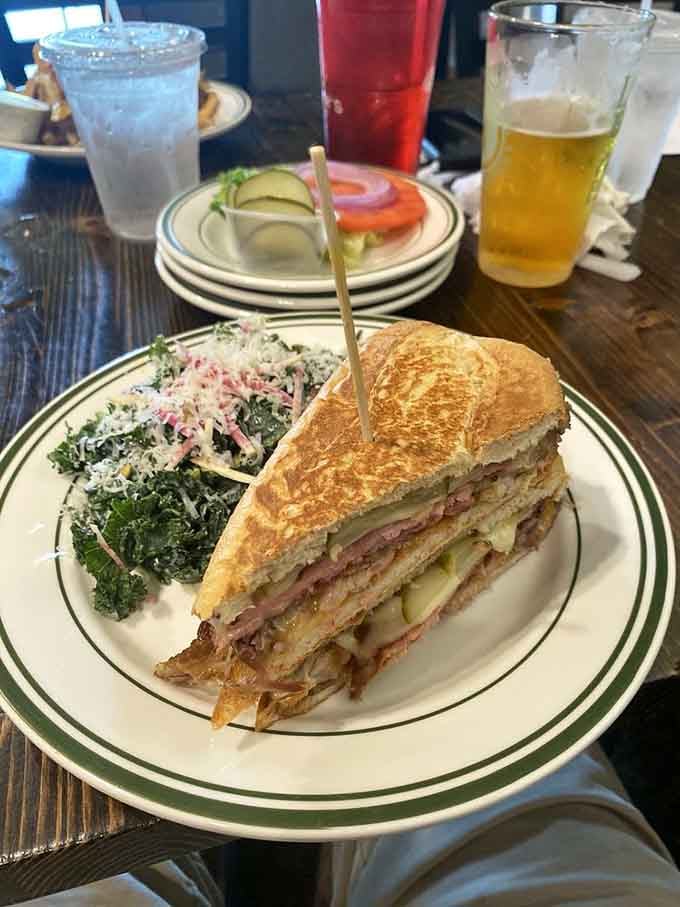 This Cuban sandwich doesn't need a passport to transport you—layers of flavor stacked between perfectly pressed bread with kale salad riding shotgun.