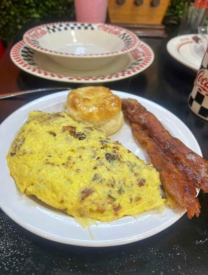 An omelet so loaded with goodness it needs its own zip code, paired with bacon and a biscuit that means business.