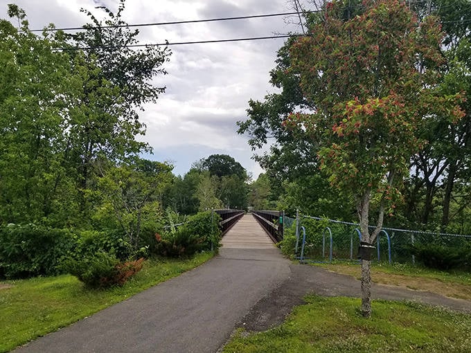 Walking paths invite exploration along Debe Park Trails, where the simple wooden bridge promises adventures on the other side without requiring a passport.