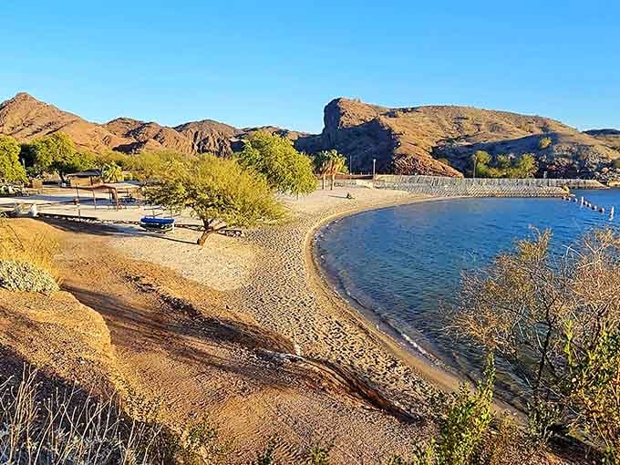 A perfect crescent of golden sand embraced by desert hills. This hidden beach cove offers the ideal balance of sun and shade.