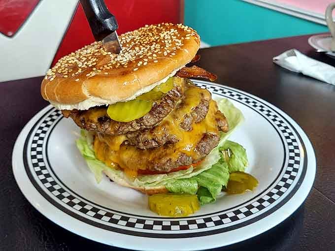 This towering burger with its sesame seed bun demands respect, a napkin strategy, and possibly an engineering degree.