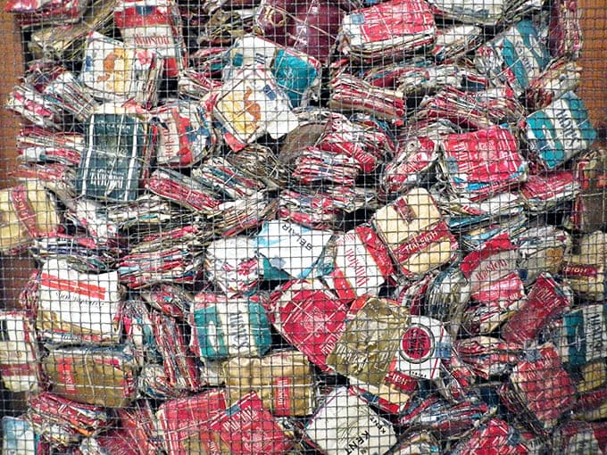 Behind wire mesh sits a collection of cigarette packages, documenting when smoking was actually prescribed as therapeutic treatment.