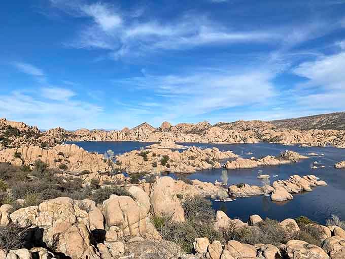 The lake wraps around these boulders like it's giving them the world's most scenic group hug.