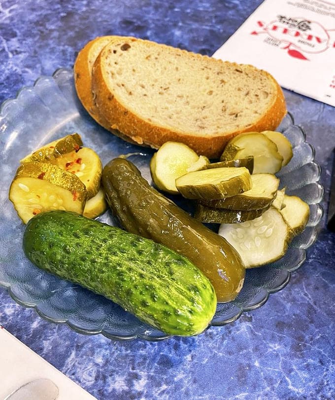 Fresh pickles and rye bread arrive before your meal, a delicious warning of what's coming.