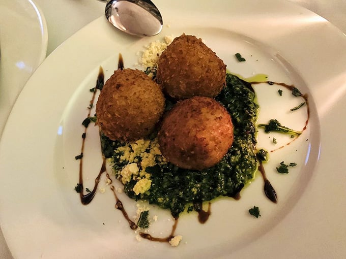 Golden-fried risotto balls perched on greens like edible treasures that crunch outside and melt inside with creamy, dreamy goodness.