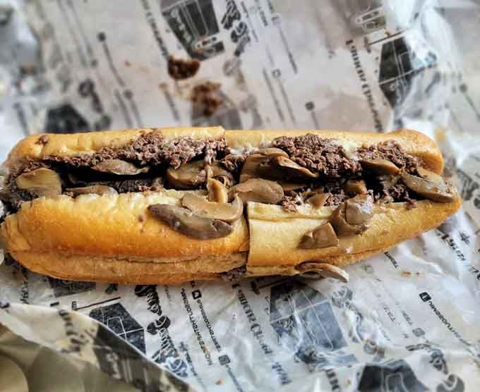 That side view shows the perfect bread-to-filling ratio, like a delicious architectural blueprint wrapped in paper.