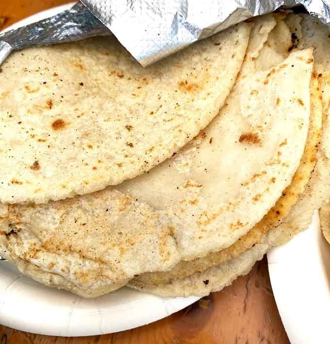 Fresh handmade tortillas with those perfect golden spots that prove someone actually cares about your lunch.