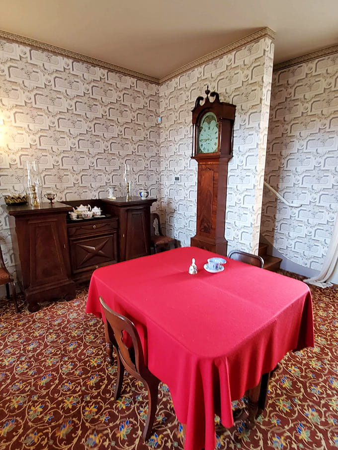 The grandfather clock keeps perfect time while that red tablecloth adds drama worthy of a Masterpiece Theatre set.