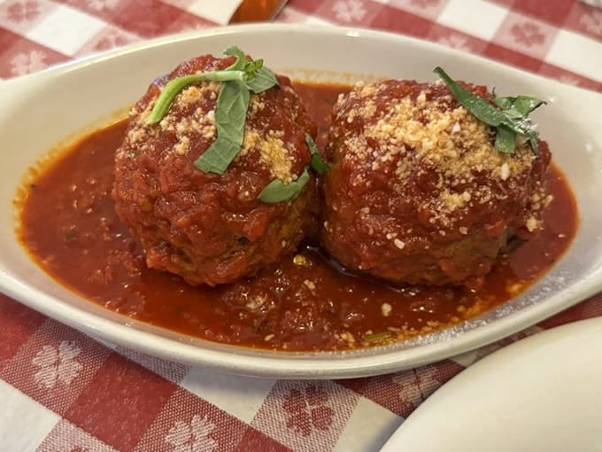 Two meatballs swimming in sauce, topped with basil and cheese &ndash; simple perfection that needs no introduction whatsoever.