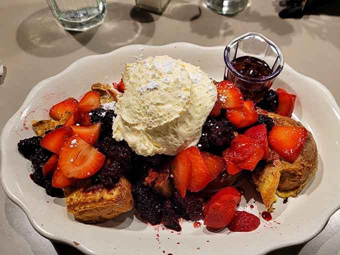 French toast piled with berries and whipped cream, because sometimes breakfast needs to look like a celebration.