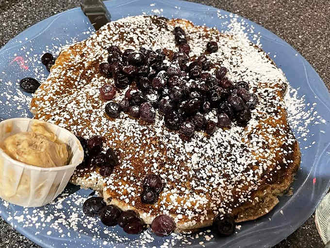 Blueberry pancakes dusted with enough powdered sugar to make a snow globe jealous of its coverage.