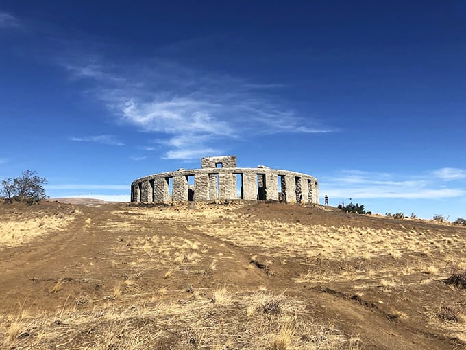Rising from golden hills like a mirage, this concrete circle commands attention against the endless blue horizon.