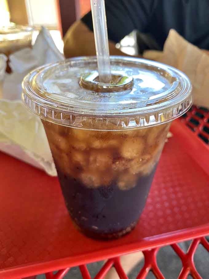 That dark, creamy root beer in a plastic cup proves perfection doesn't need fancy presentation, just honest flavor.