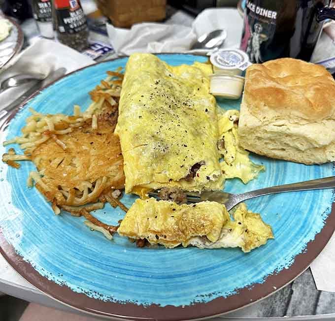 A properly stuffed omelet with crispy hash browns and a fluffy biscuit, because breakfast should never leave you wanting more.