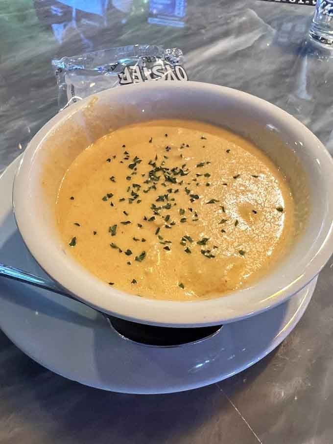 That creamy, golden bisque topped with herbs looks like liquid comfort in a bowl, perfect for seafood lovers.