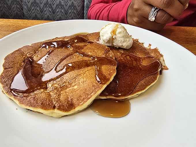 Golden pancakes drizzled with syrup and butter, looking like edible sunshine that arrived just in time for your morning.