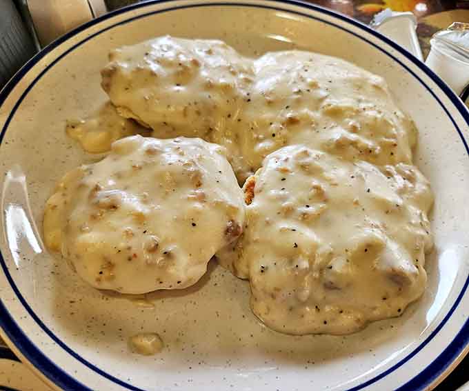 Four biscuits drowning in sausage gravy, the kind of Southern comfort that makes you forget about portion control entirely.