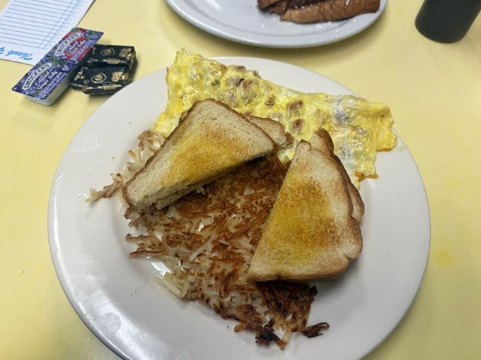 That fluffy omelette and golden hash browns are basically a warm hug on a plate with toast.