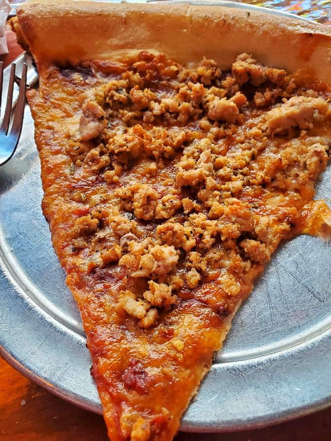 That golden crust and crumbled sausage topping create the kind of pizza slice that haunts your dreams in the best way.