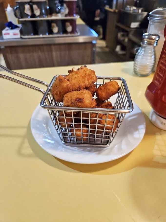 Golden-fried cheese curds arrive in their own tiny basket, because even the sides deserve their moment of glory.
