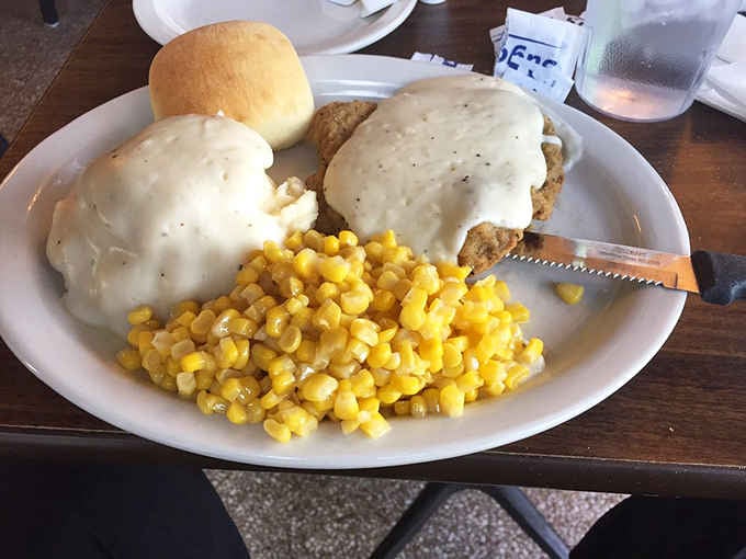 Country-fried steak smothered in gravy with a side of corn is breakfast comfort food at its absolute finest.