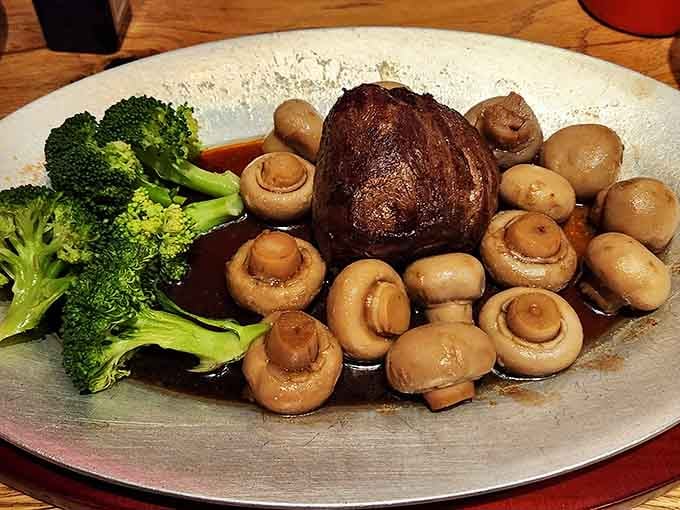 Filet mignon swimming in mushrooms and accompanied by vibrant broccoli proves that steakhouses can do vegetables when they feel like it.