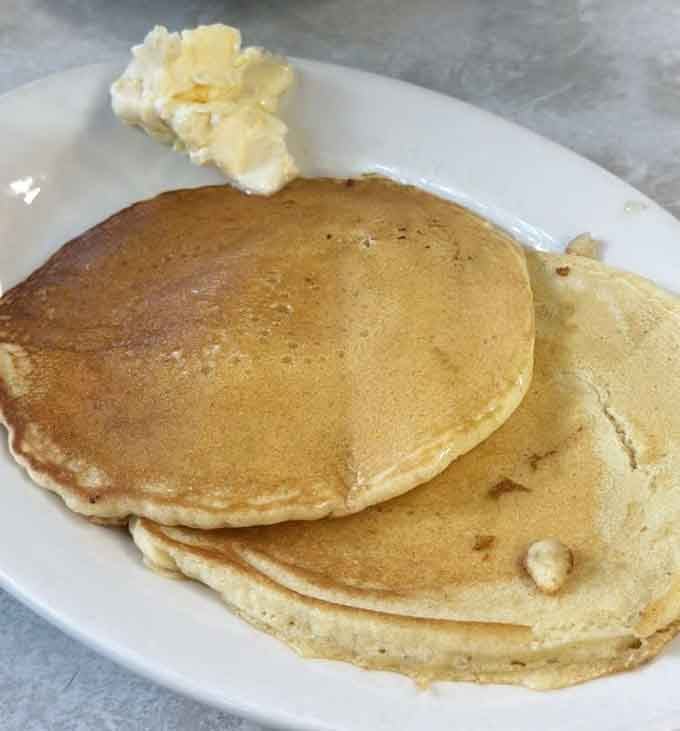 Golden pancakes topped with butter, ready to soak up syrup like they were born for this moment.