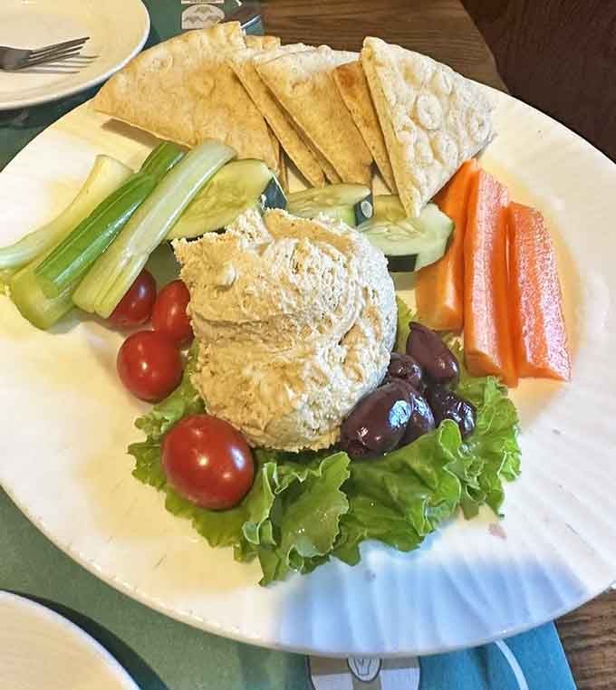 This hummus plate arrives like a rainbow decided to become an appetizer, complete with fresh veggies and warm pita.