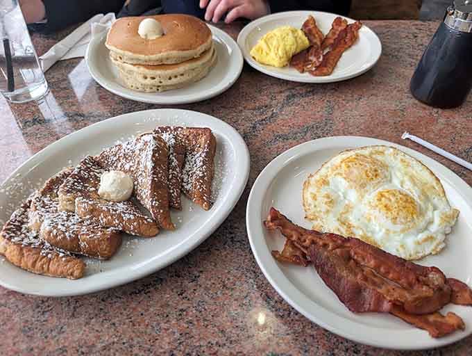 French toast dusted with powdered sugar sits next to perfectly cooked eggs, proving variety is breakfast's best friend.