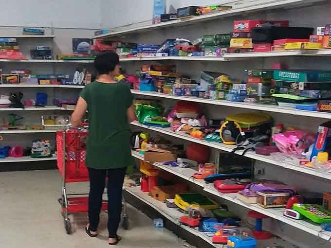 Shelves overflow with colorful kitchen treasures, each piece ready to brighten someone's cooking adventures anew.