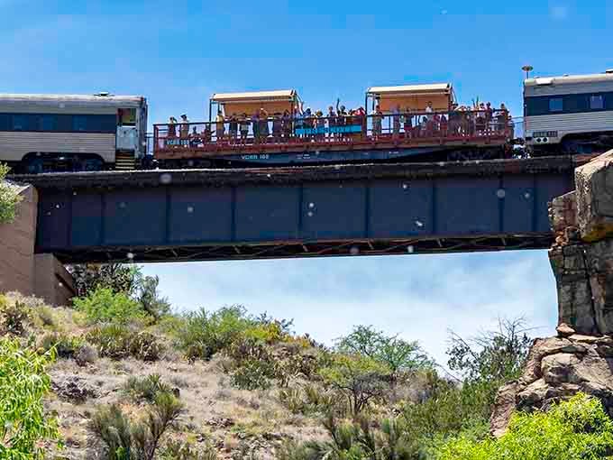 Passengers lean out to catch every angle of the canyon, cameras clicking like a symphony of shutterbugs.