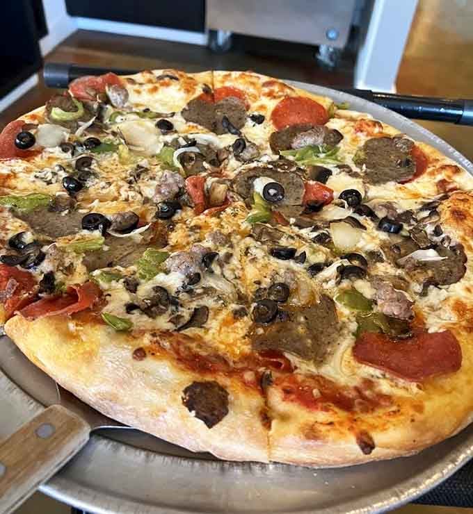 Loaded with toppings and zero regrets, this fully-dressed pie shows why people gladly cross water for lunch.