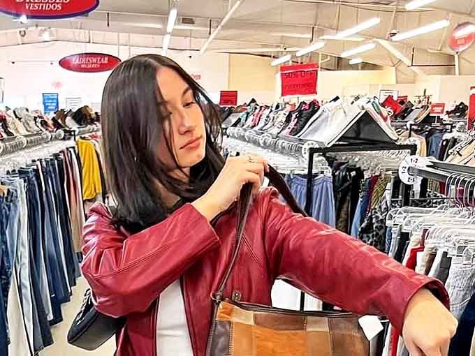 The thrill of discovery is written all over her face as she examines a perfect red leather jacket. Some treasures are worth the hunt.