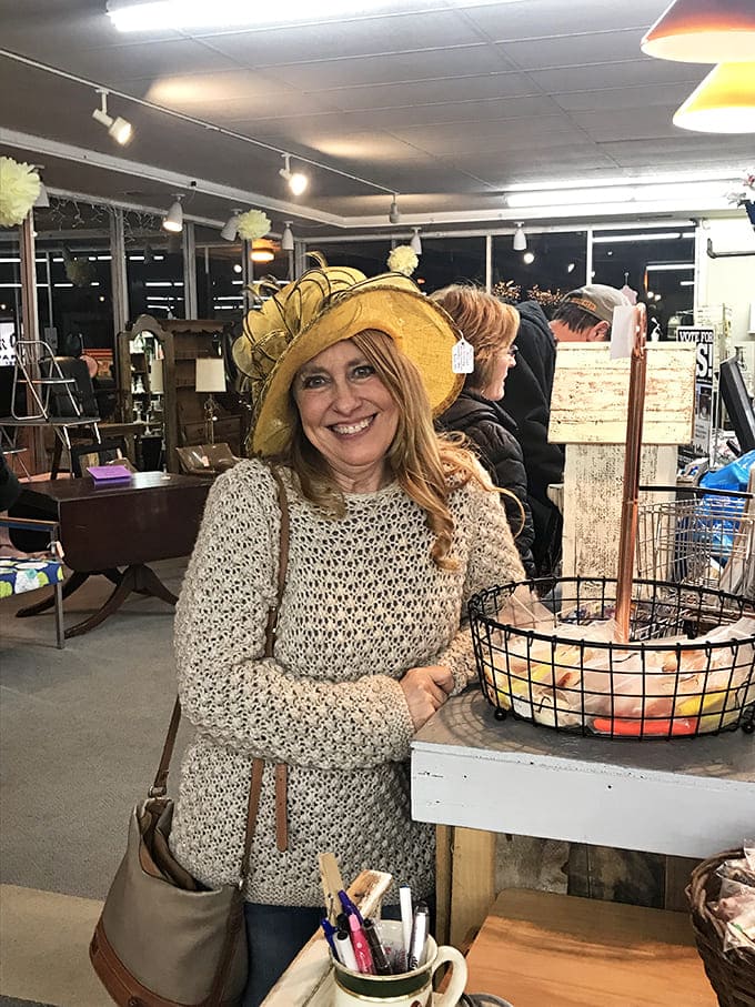A happy shopper modeling a statement hat that's found its perfect match &ndash; thrifting joy in its purest form.