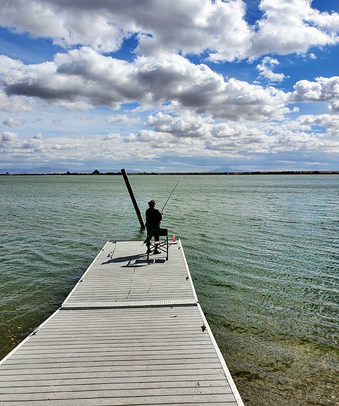 Patience personified: A lone angler waits for the perfect catch under Idaho's impossibly vast sky.