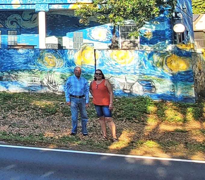 The vibrant blue backdrop creates the perfect photo opportunity for visitors. Even the Spanish moss seems to pause and appreciate this artistic anomaly.