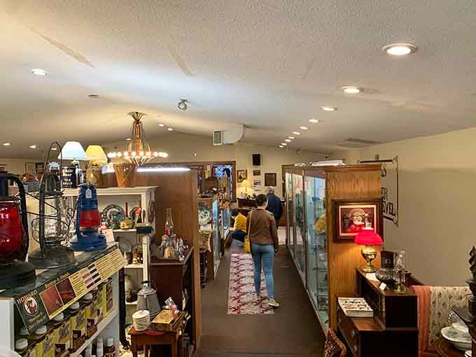 The organized chaos of a well-curated antique shop, where chandeliers hang overhead and treasures wait in every direction.