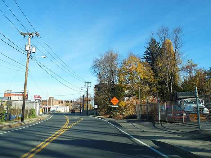 Autumn colors paint the roadside while power lines crisscross overhead like nature's own connect-the-dots puzzle in the sky.