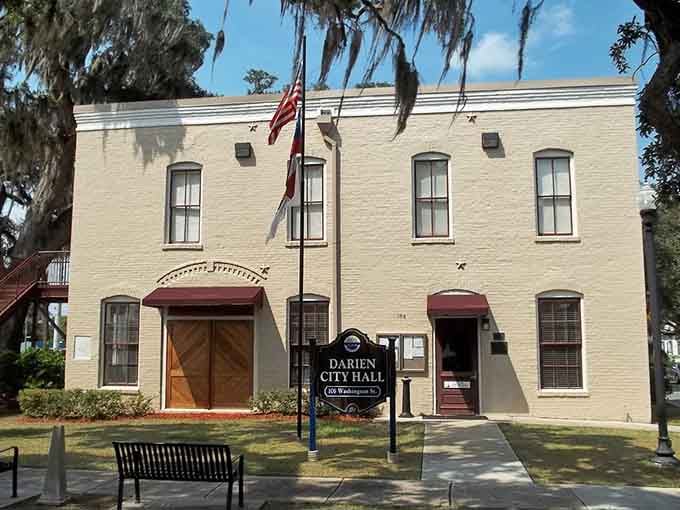 Spanish moss drapes the old city hall like nature's curtains, while that pale yellow paint glows in coastal sunlight.